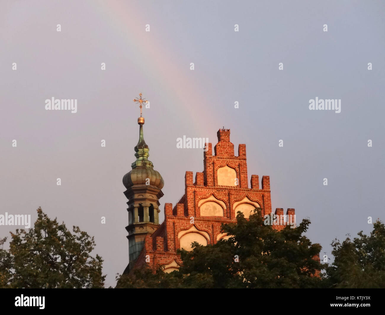 This image captures a view of a cathedral building with a rainbow in ...