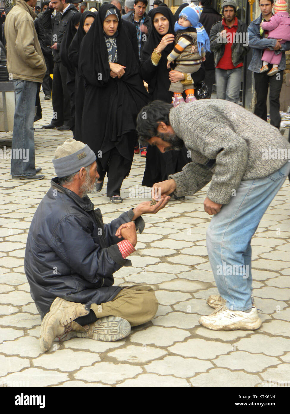 This image captures beggars in the street, depicting a social issue ...