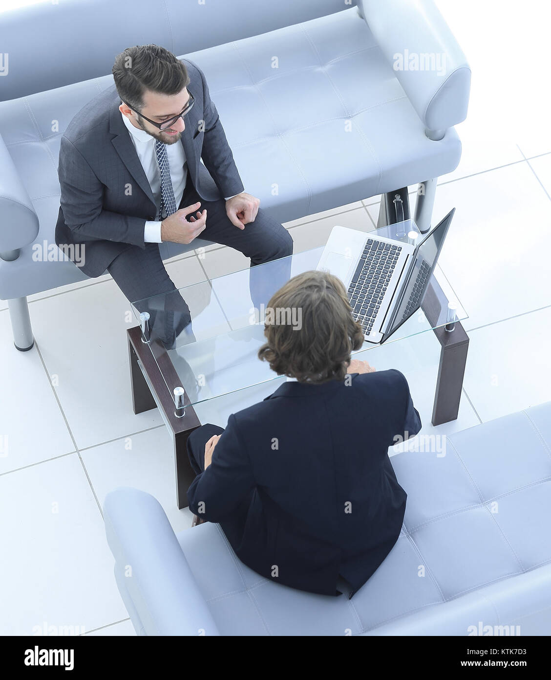 Two businessmen discussing tasks sitting at office table Stock Photo ...