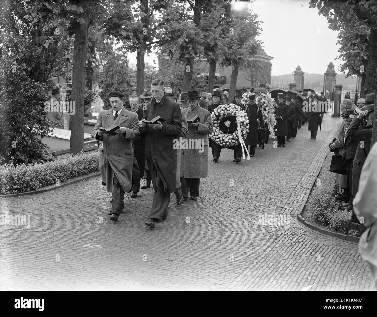 A funeral ceremony, documented in a historical photograph, capturing ...