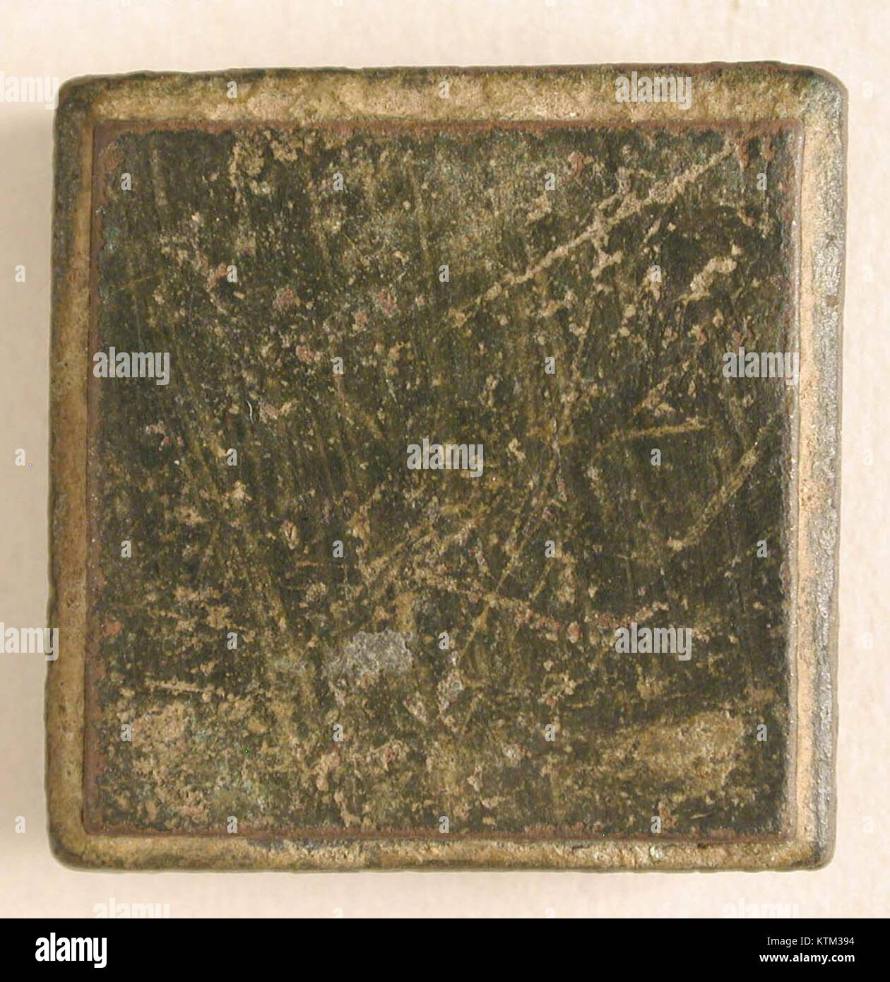 A balance weight featuring a monogram, used in scientific or mechanical ...