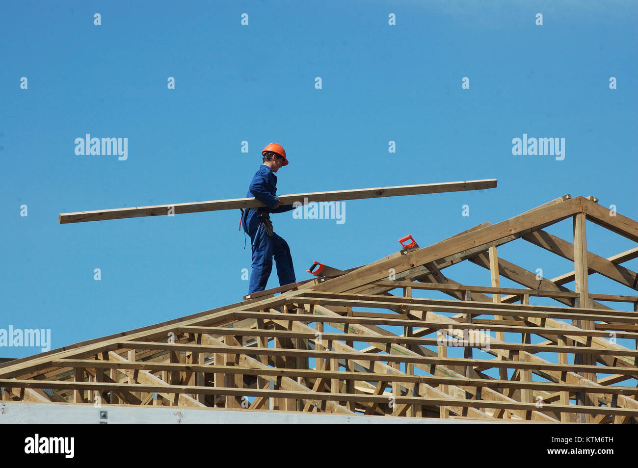 builder carrying timber for the roof framing Stock Photo - Alamy