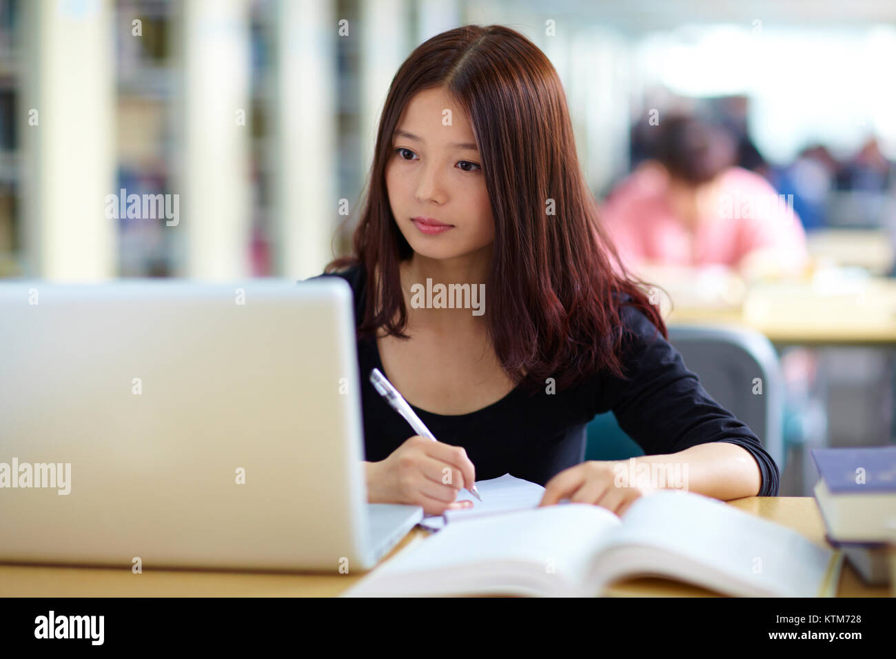 one young Chinese female univeristy student study in the library with ...