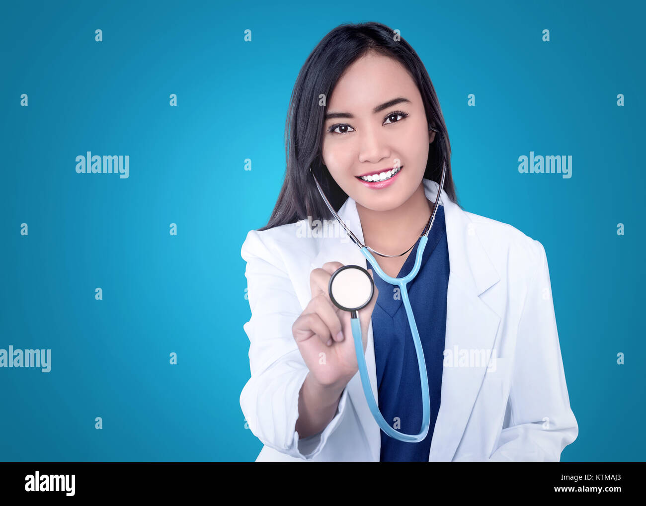 Beautiful asian doctor woman with a stethoscope over blue background ...