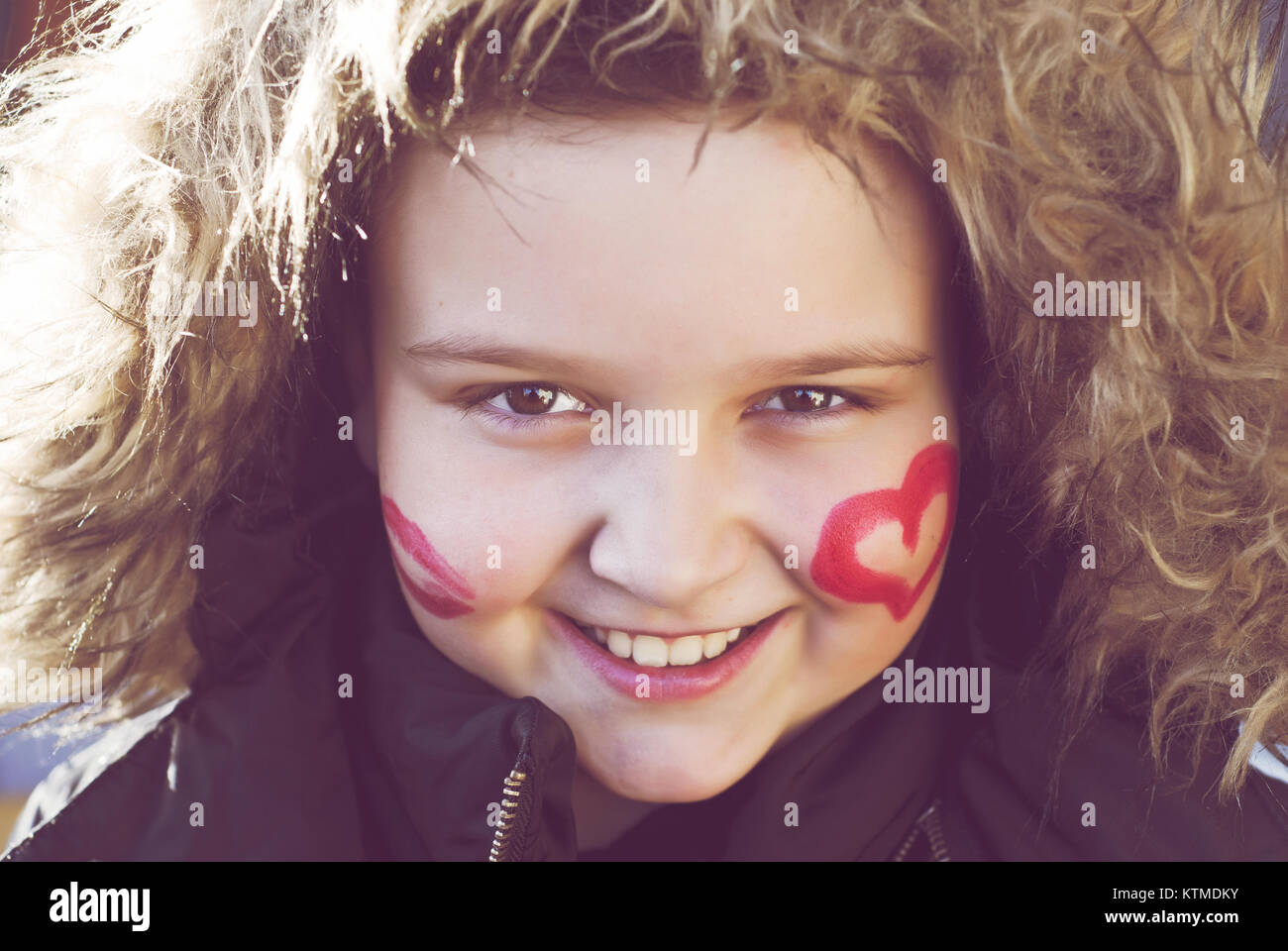Happy little boy with painting hearts on cheeks. Crazy child Stock ...