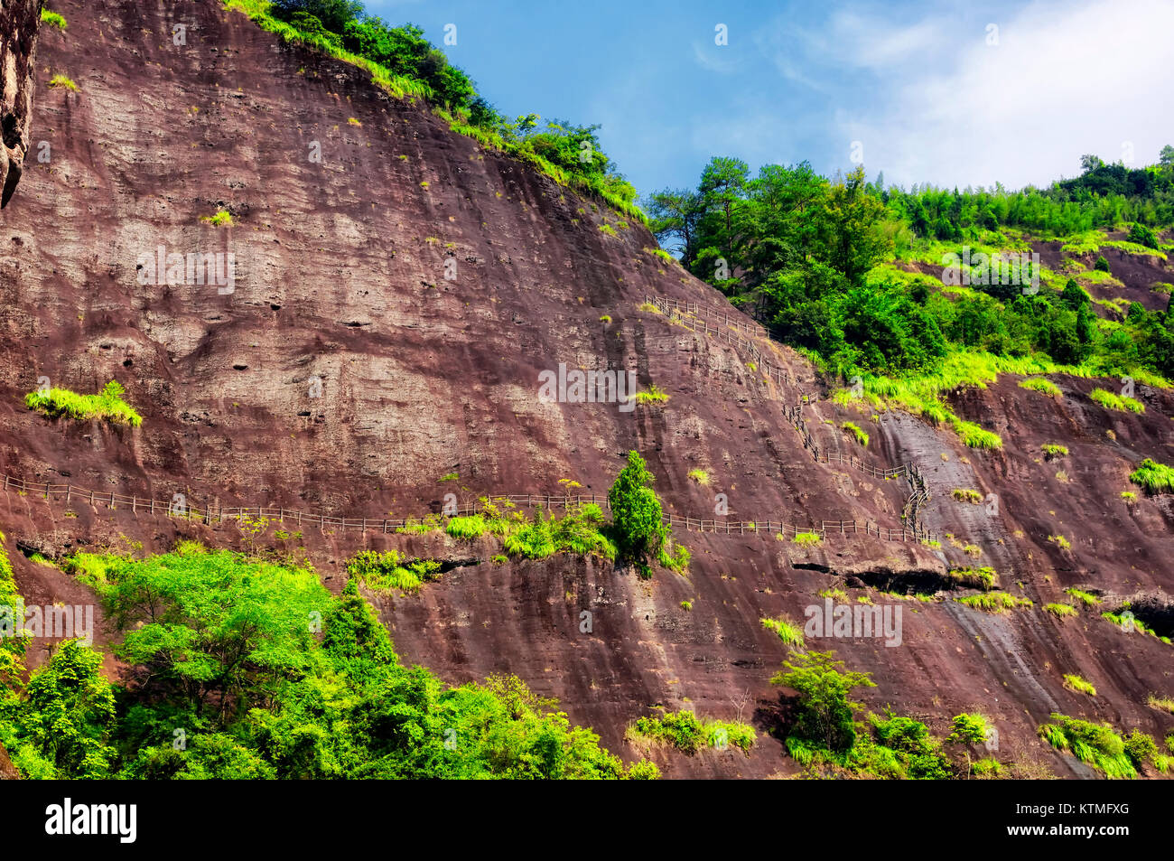 A rock cliff lining the nine bend river or Jiuxi in Wuyishan or Mount ...