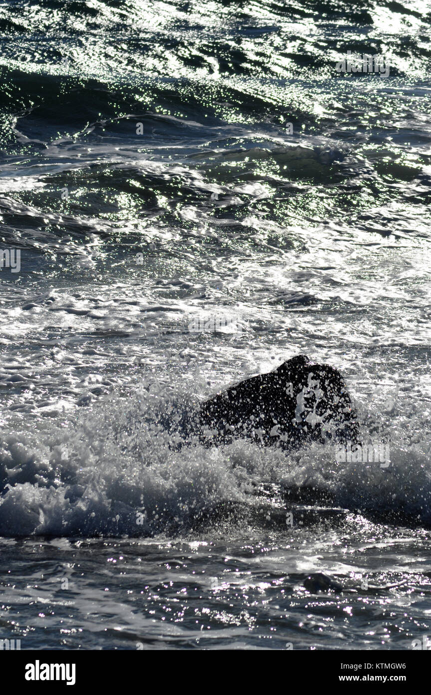 Backlight of the sea with waves and metallic color Stock Photo - Alamy