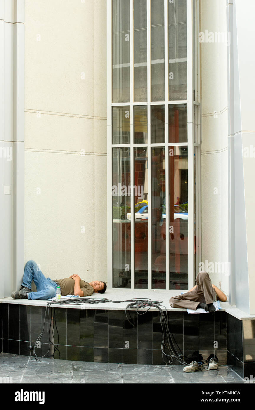 SINGAPORE – february 25, 2011 : tired worker doing a rest while working ...