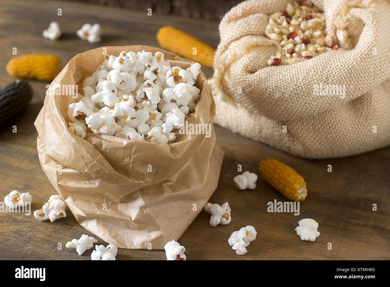 Pop corn, corn grain and cobs on a wooden background. Rustic style ...