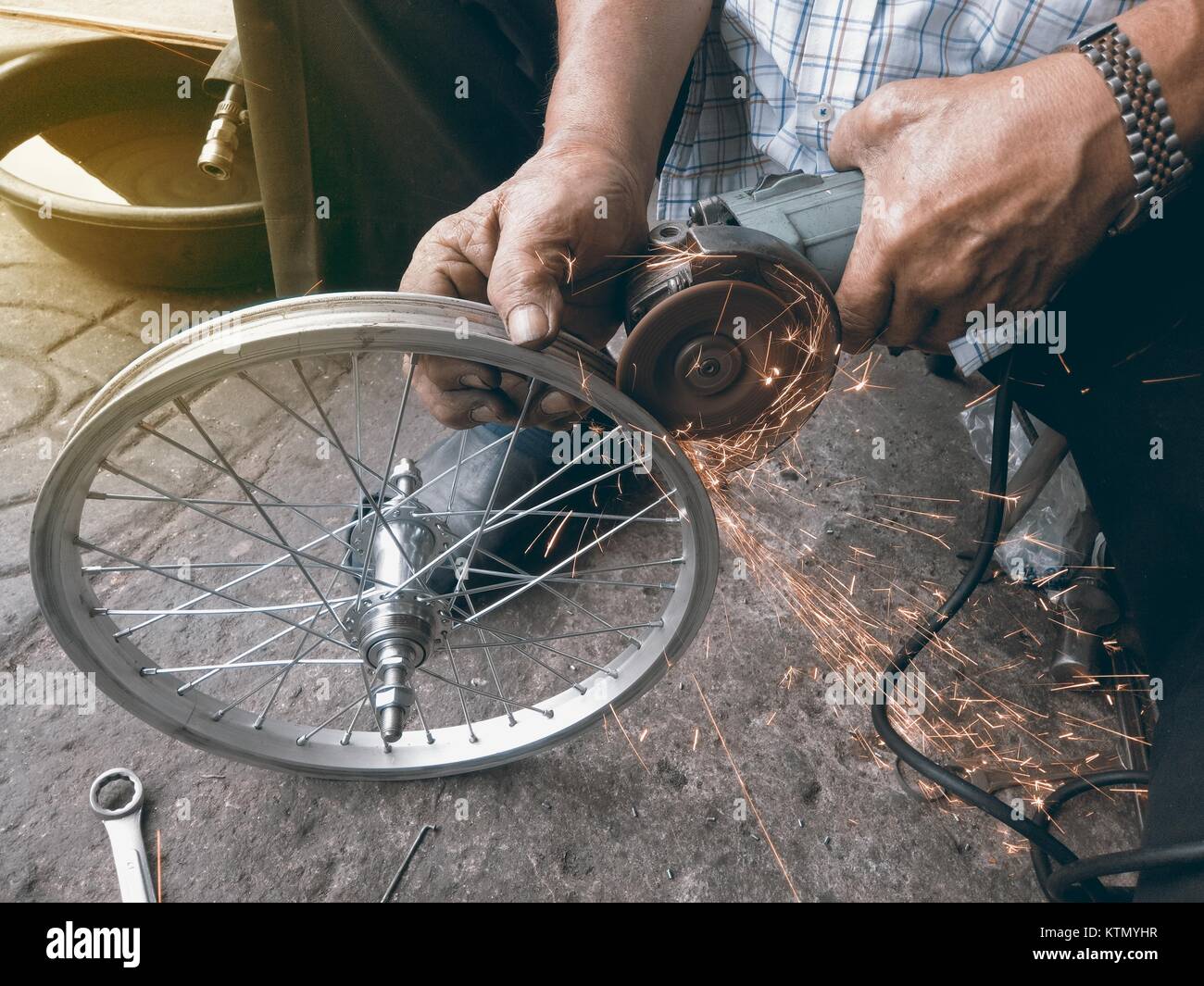 Grinding machine works and sparking with bicycle wheel by male Stock ...