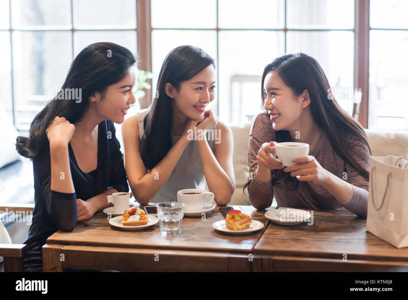 Best female friends drinking coffee in café Stock Photo - Alamy
