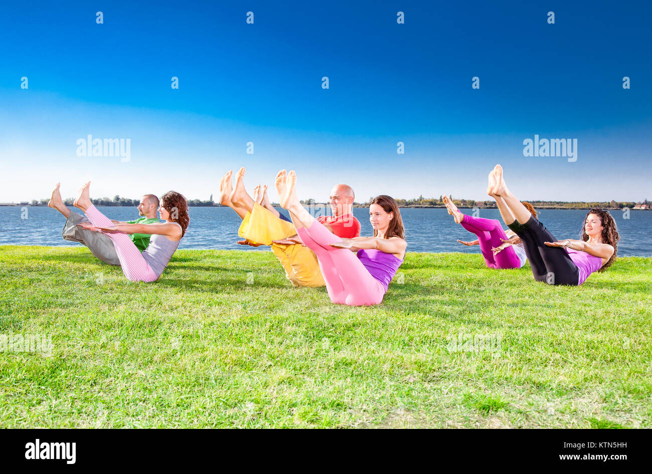 Young people practice Yoga asana on lakeside. Yoga concept Stock Photo ...