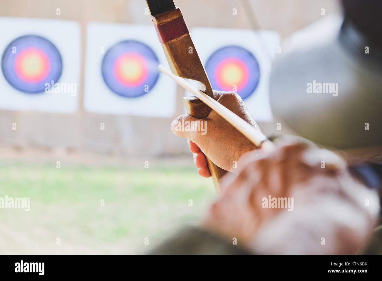 Archer holds his bow aiming at a target Stock Photo - Alamy