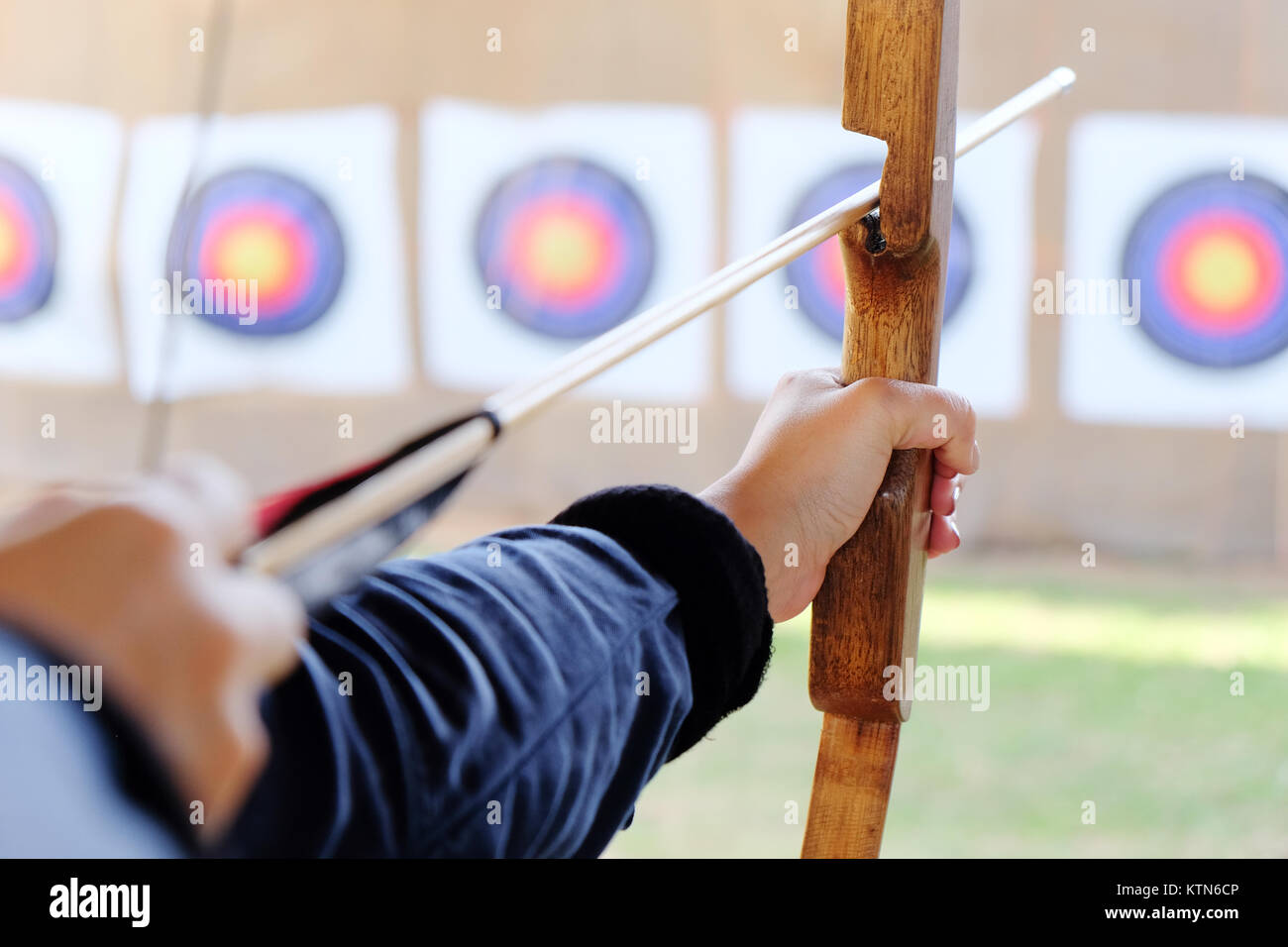 Archer holds his bow aiming at a target Stock Photo - Alamy