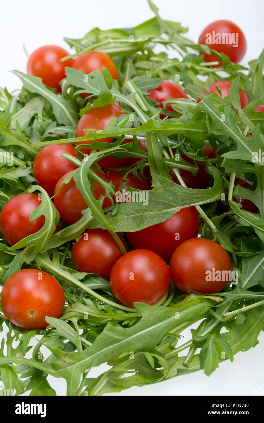 Heap of ruccola leaves and cherry tomatoes Stock Photo - Alamy