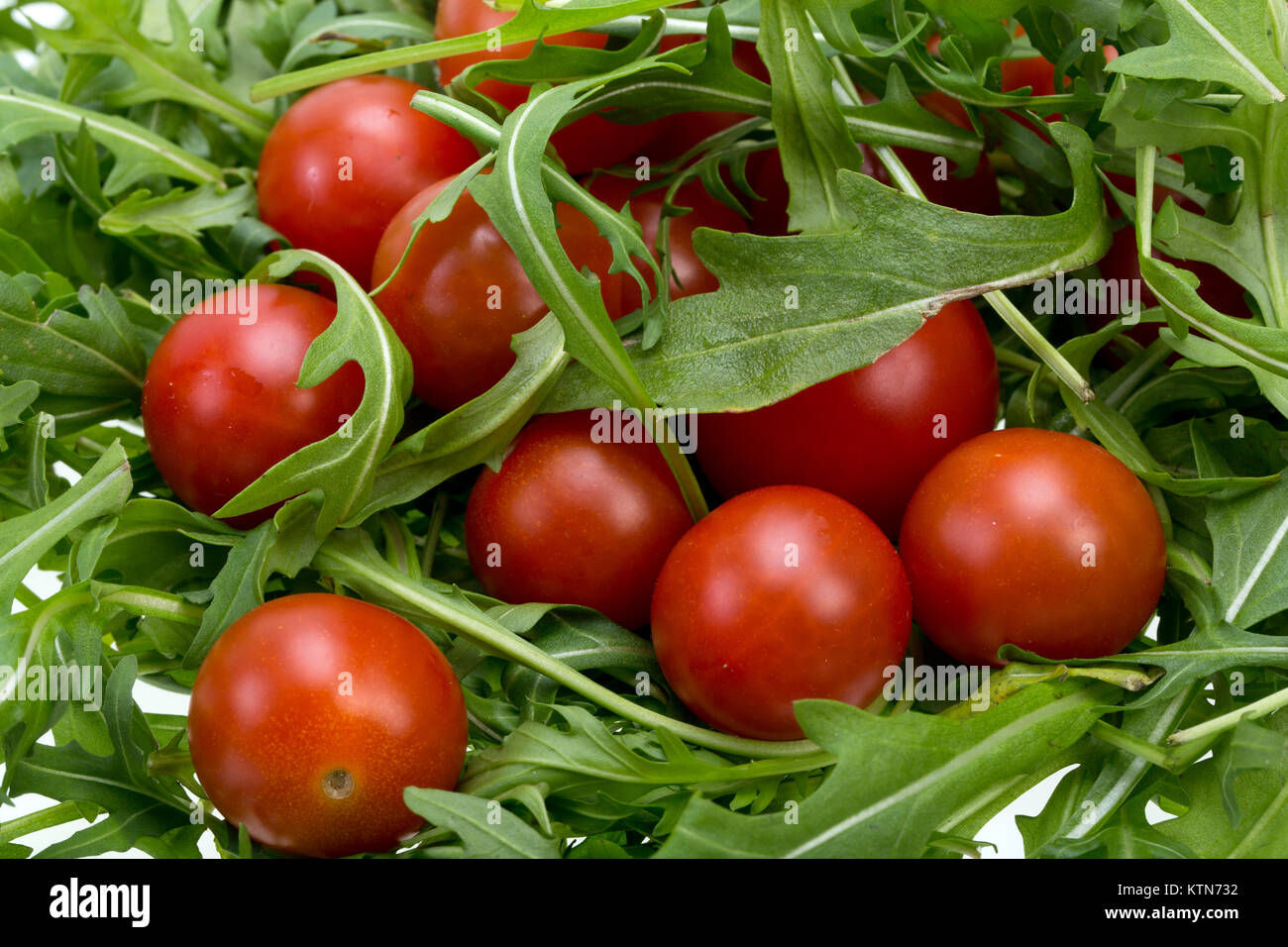 Heap of ruccola leaves and cherry tomatoes Stock Photo - Alamy