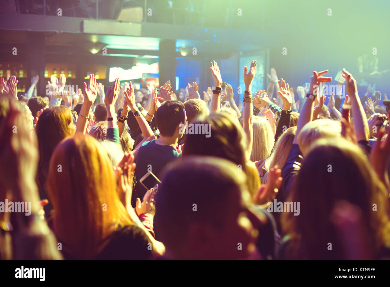 A crowd of spectators at a concert in a small concert club. Applaud and ...