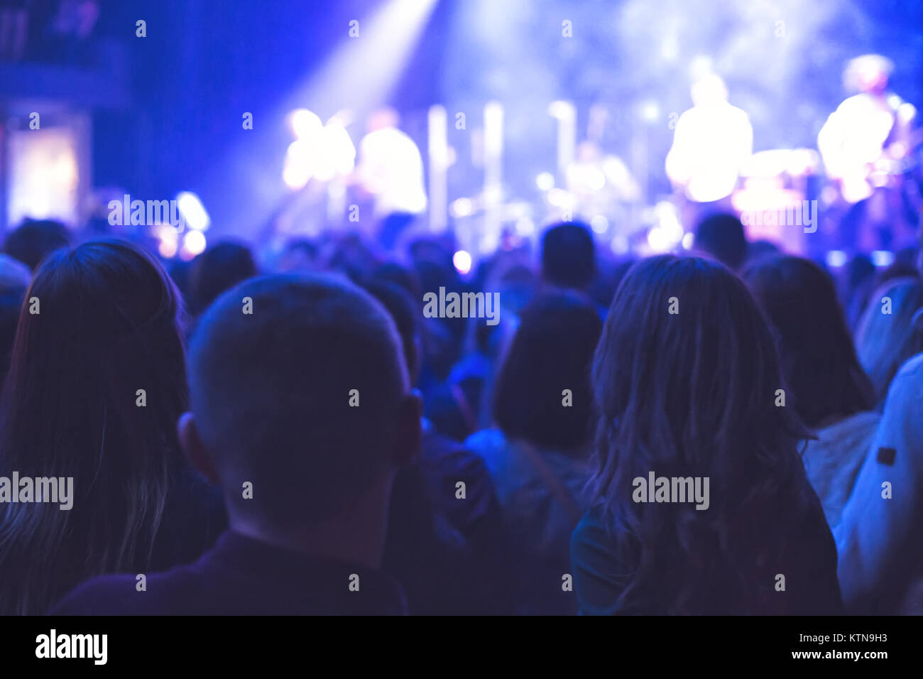 A crowd of spectators at a concert in a small concert club. Applaud and ...
