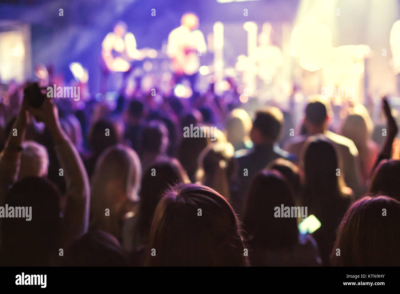 A crowd of spectators at a concert in a small concert club. Applaud and ...