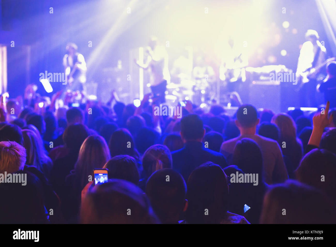 A crowd of spectators at a concert in a small concert club. Applaud and ...