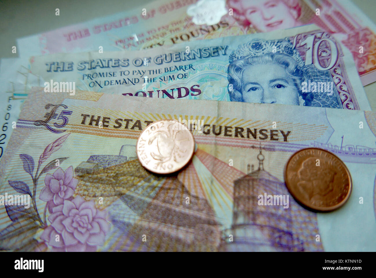 A view of bank notes and coins of the currency Guernsey Pound (GGP ...