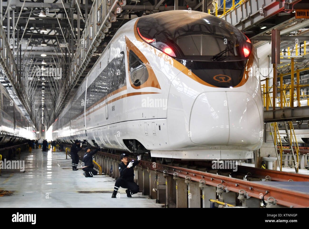 Tianjin, Dec. 27. 28th Dec, 2017. Workers examine a Fuxing bullet train ...