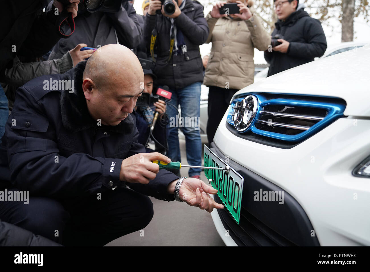 Beijing, China. 28th Dec, 2017. A staff member installs a new license ...
