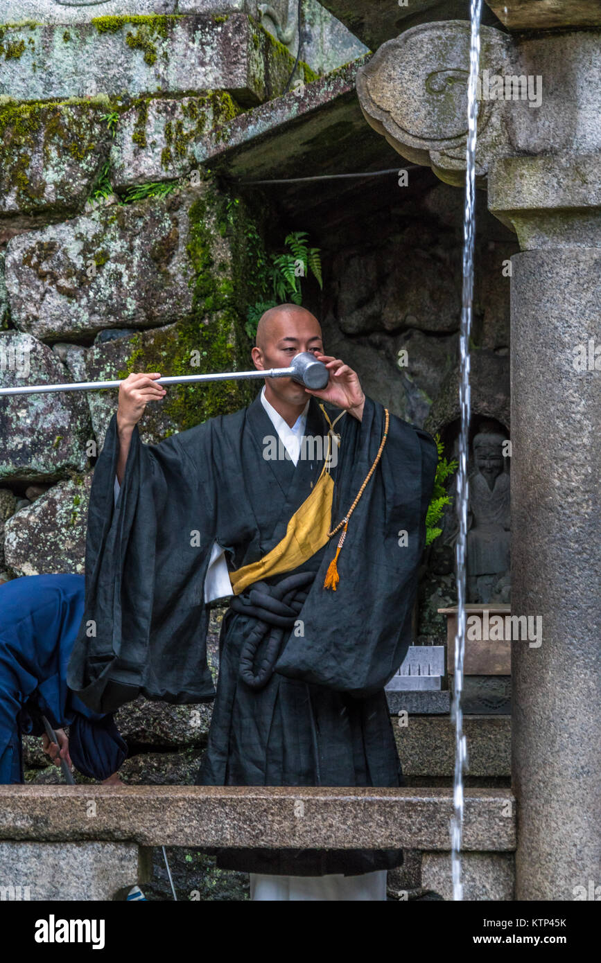 Local Monk drinking water from Otowa Waterfall (Otowa-no-Taki) which is ...