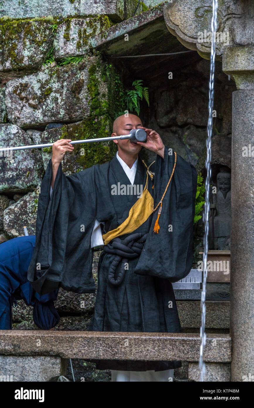 Local Monk drinking water from Otowa Waterfall (Otowa-no-Taki) which is ...