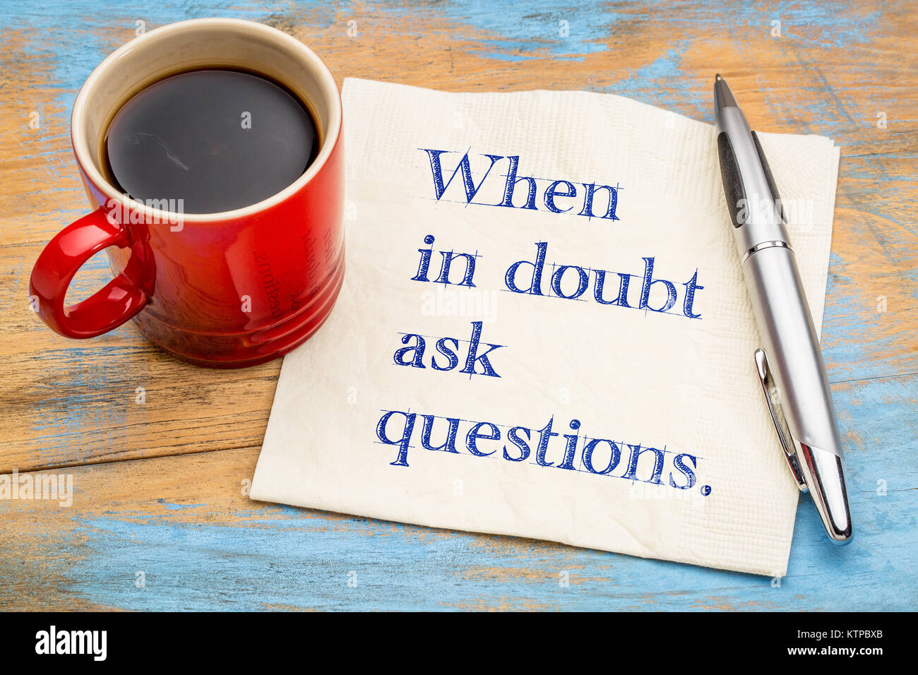 When in doubt ask questions - handwriting on a napkin with a cup of ...