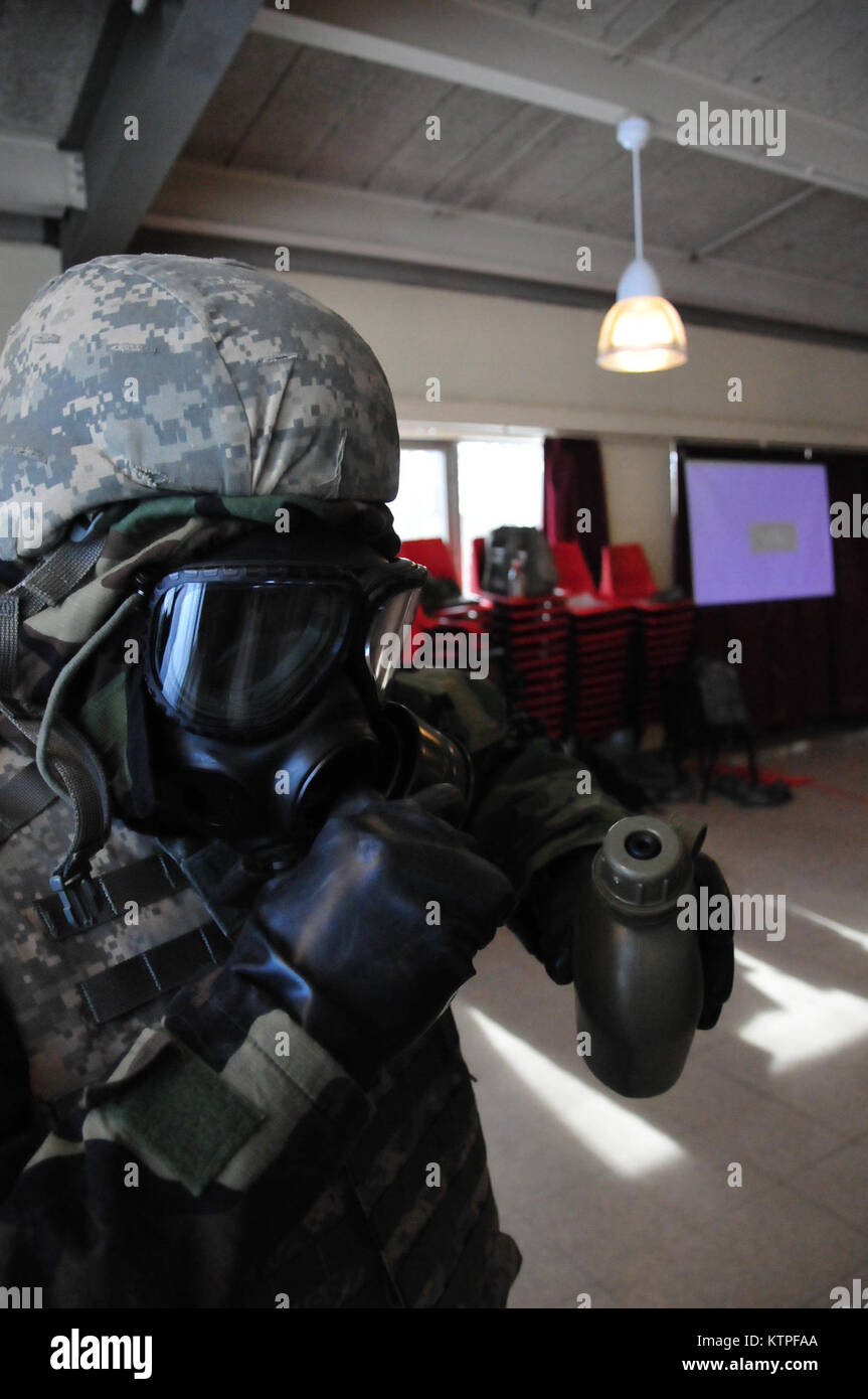 A female Soldier demonstrates how drink through her protective mask ...