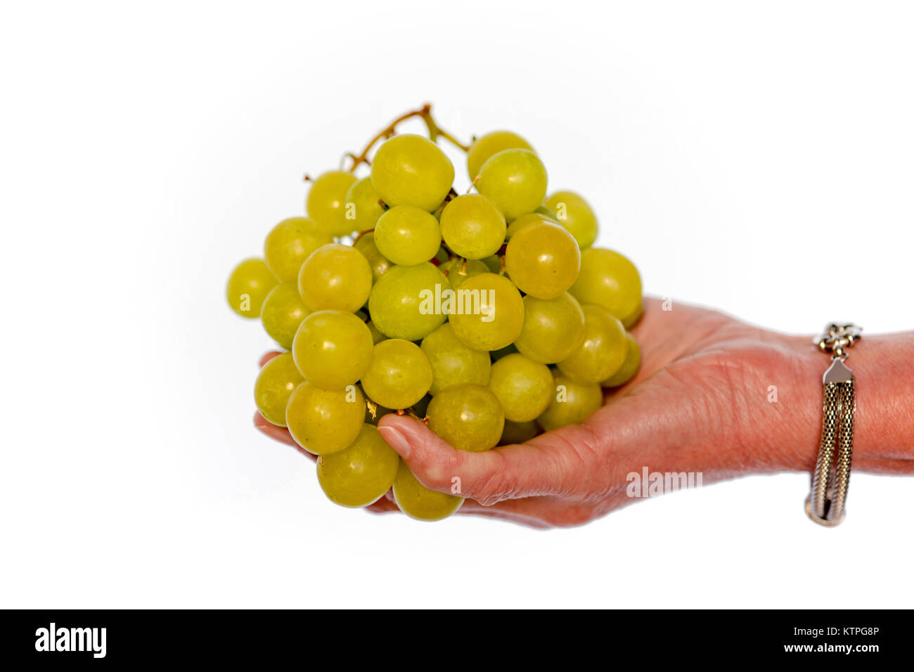 A young woman holds a big bunch with white grapes in her hand Stock ...