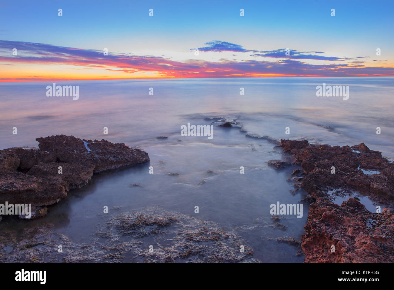 The calm sea in a very cloudy sunset in Spain Stock Photo - Alamy
