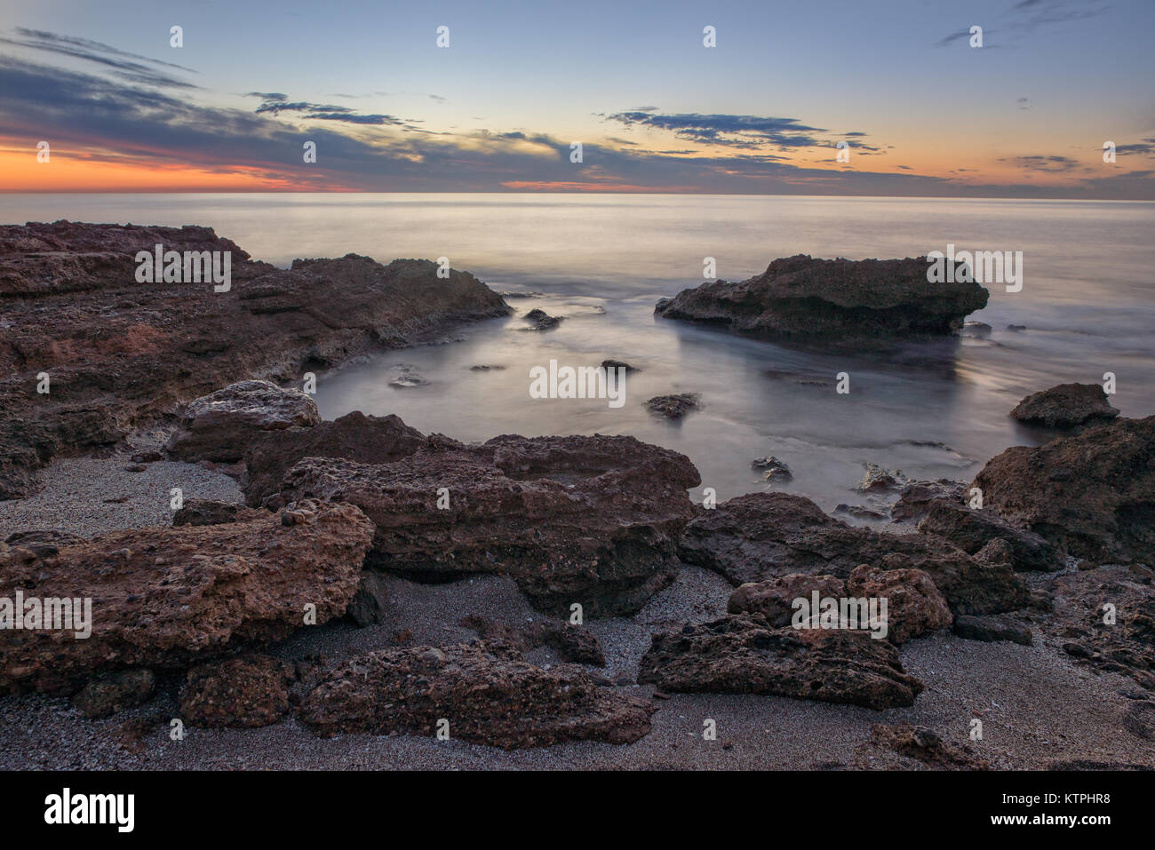 The calm sea in a very cloudy sunset in Spain Stock Photo - Alamy