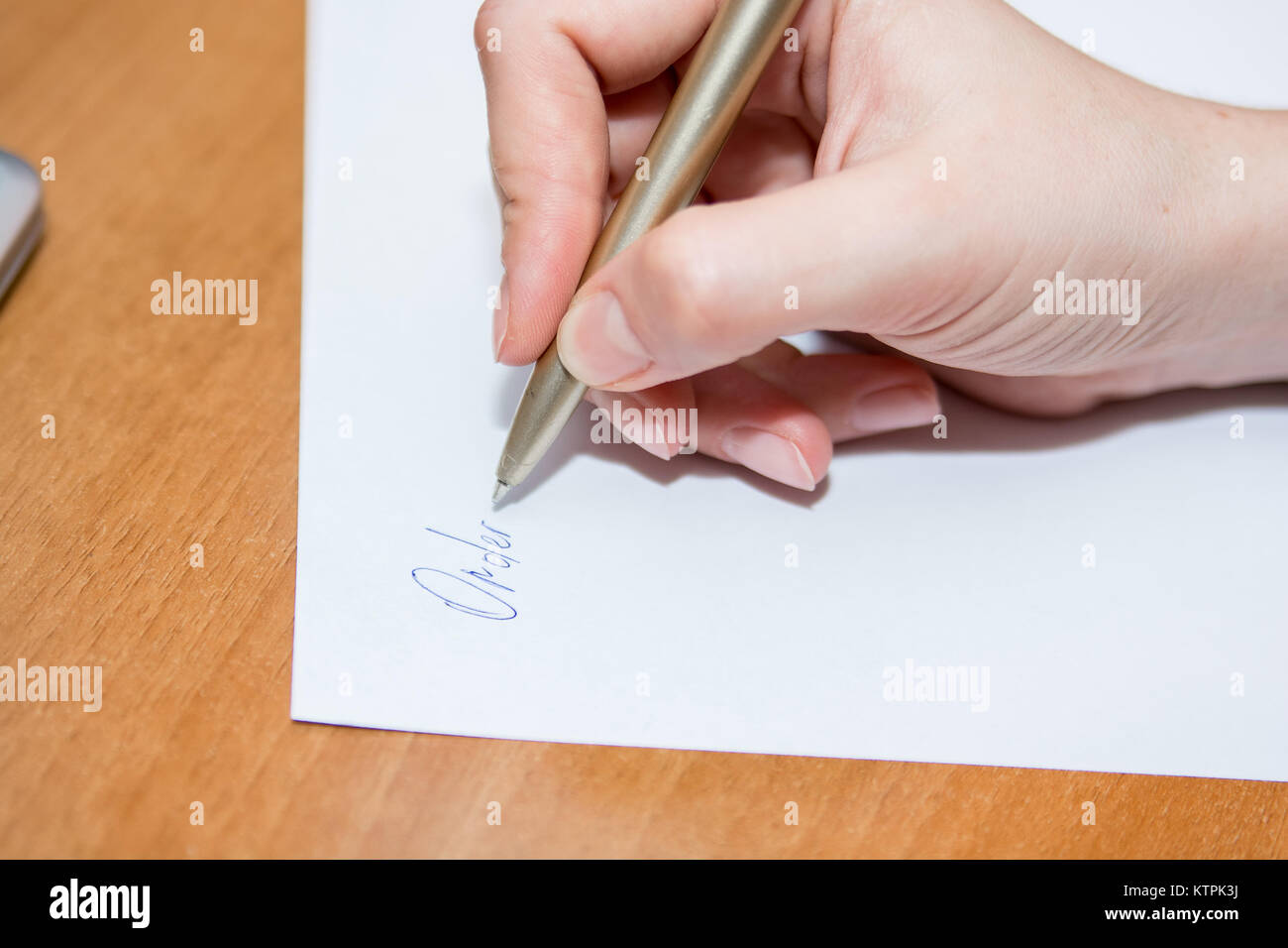 Closeup image of female hand holding pen writing the word order on ...