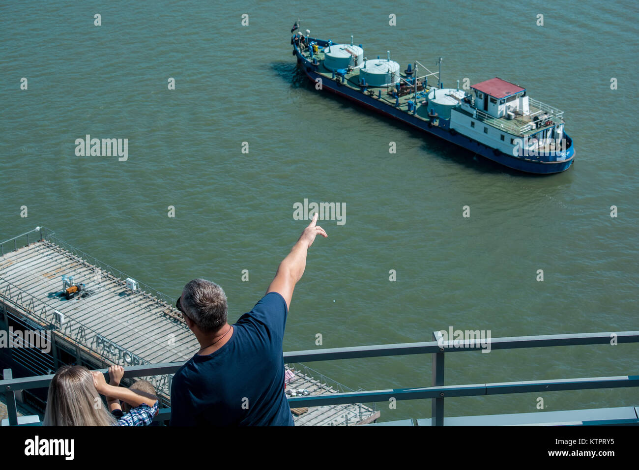 Back view of man pointing at barge on river with his finger Stock Photo ...