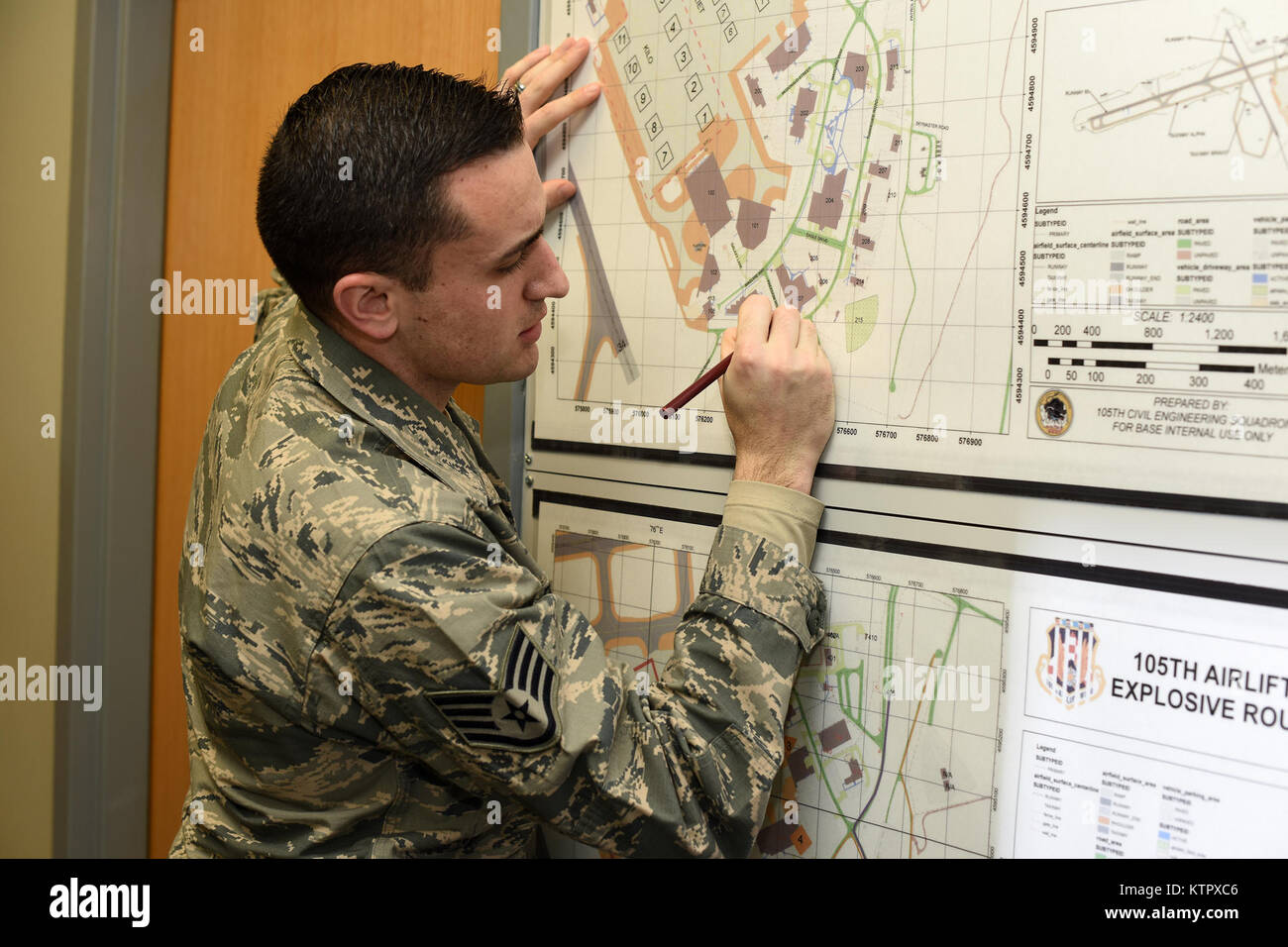 Staff Sgt. Andrew Frank, 105th Fire Department, marks the location of ...
