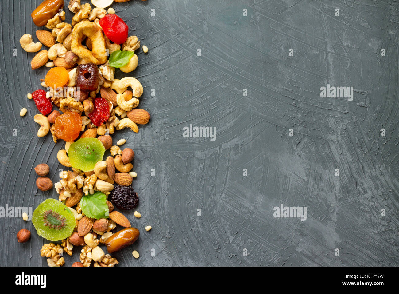 Various dried fruits and mix nuts on a gray stone or slate background ...