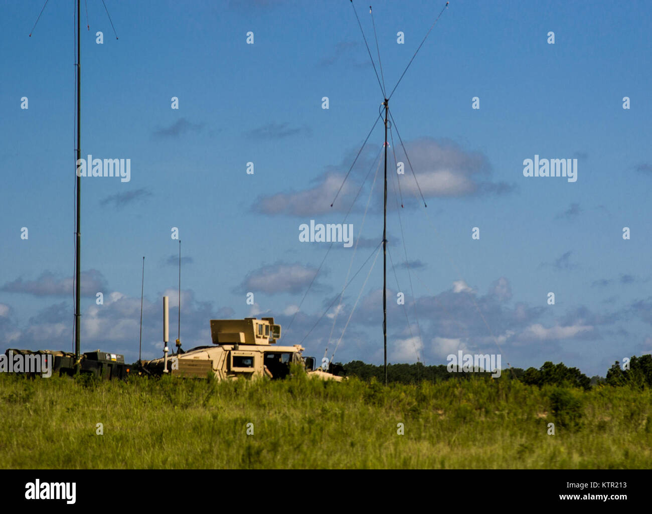 A Humvee sits atop a hill and provides security for a communication ...