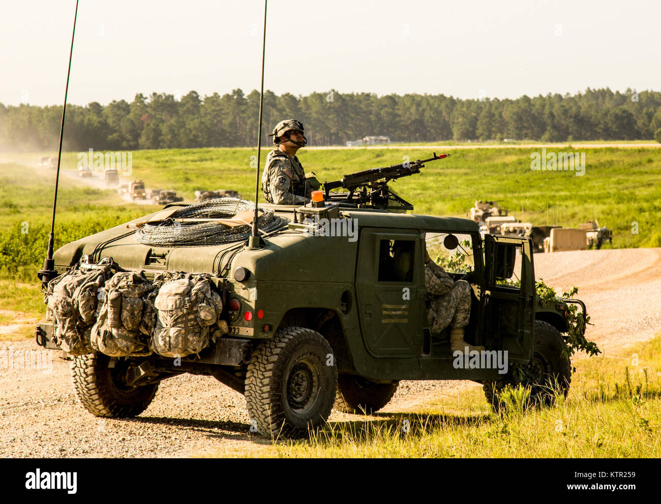 A Humvee pulls off the road while Soldiers provide security for a unit ...