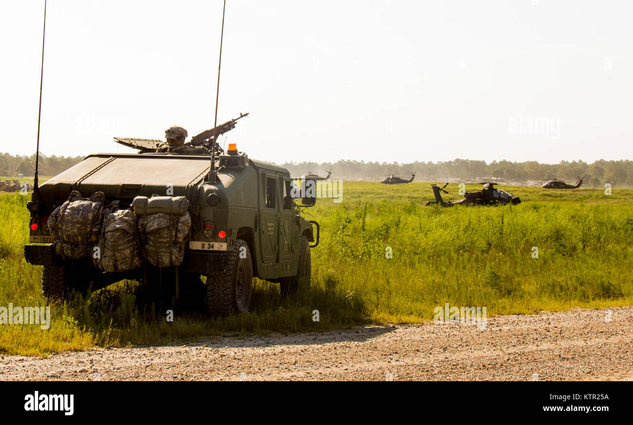 A Humvee pulls off the road while Soldiers provide security for a unit ...