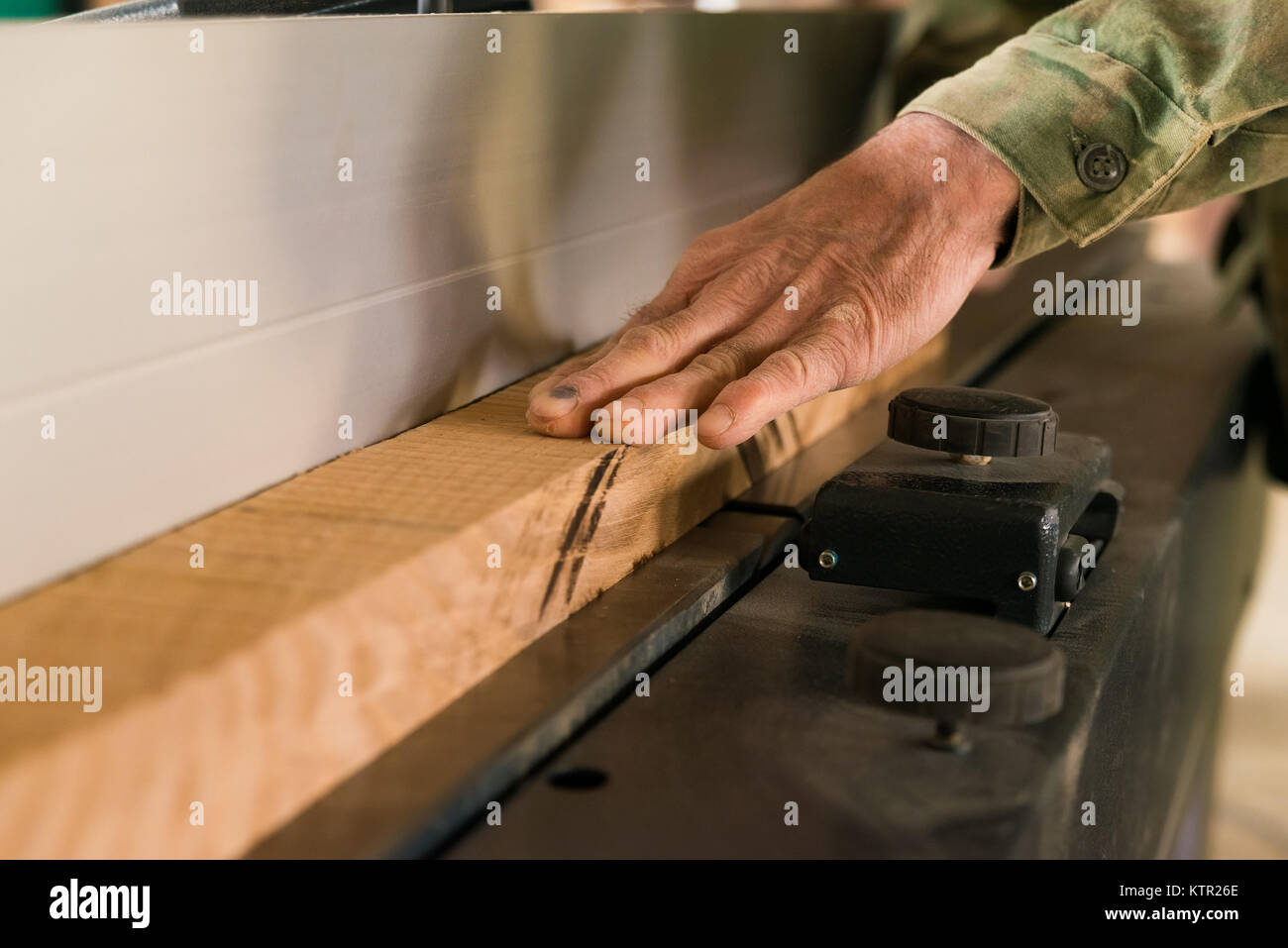 Close up hand of carpenter putting wooden beam in electric planer Stock ...