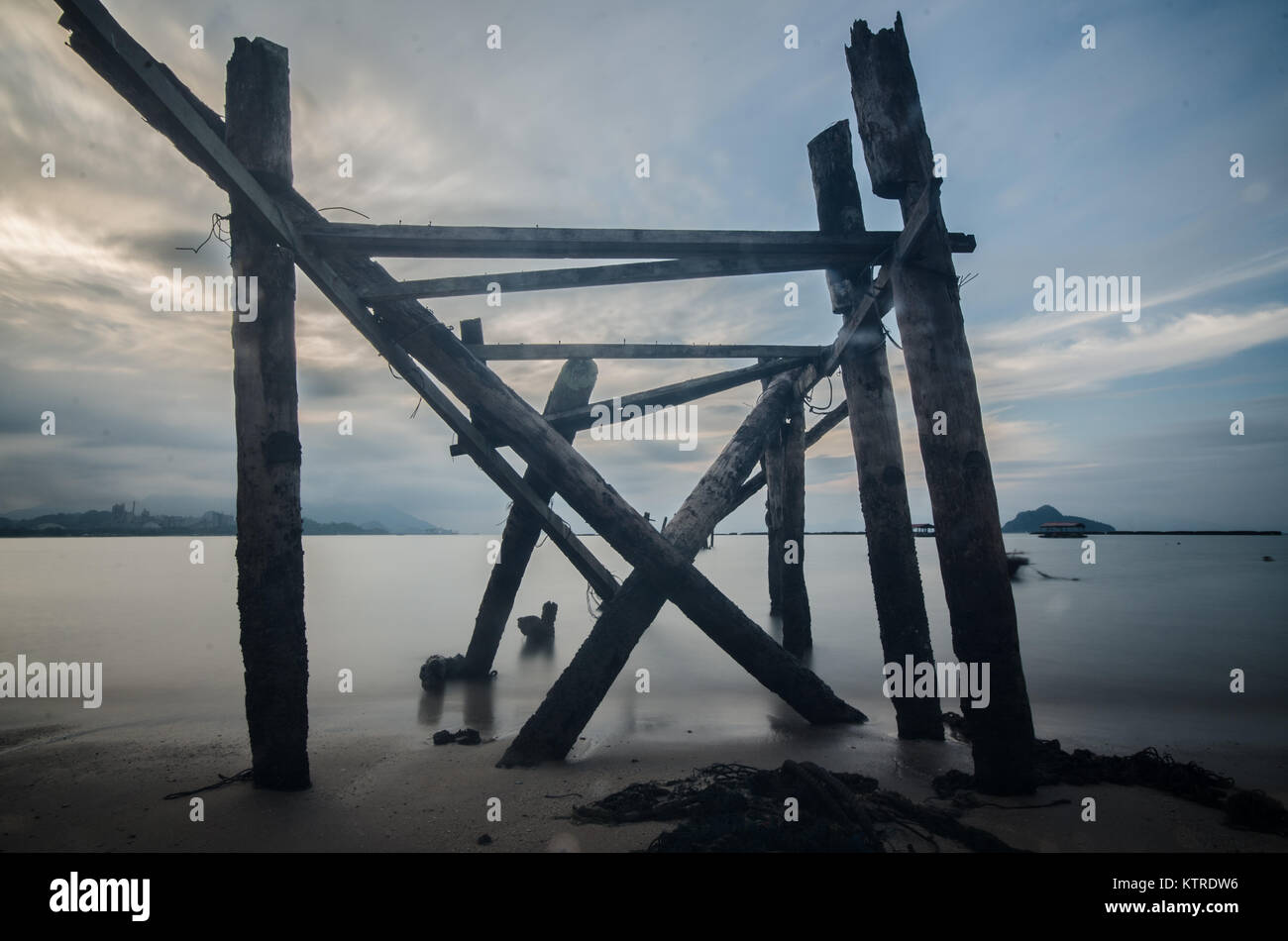 Cloudy day at old and damage boat jetty at Black Sand Beach in Langkawi ...