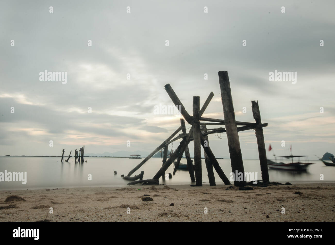 Cloudy day at old and damage boat jetty at Black Sand Beach in Langkawi ...