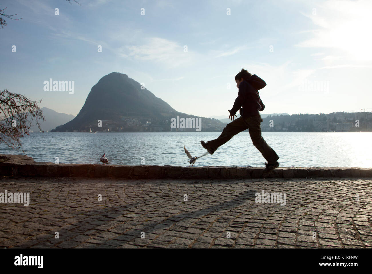children running near a lake Stock Photo - Alamy