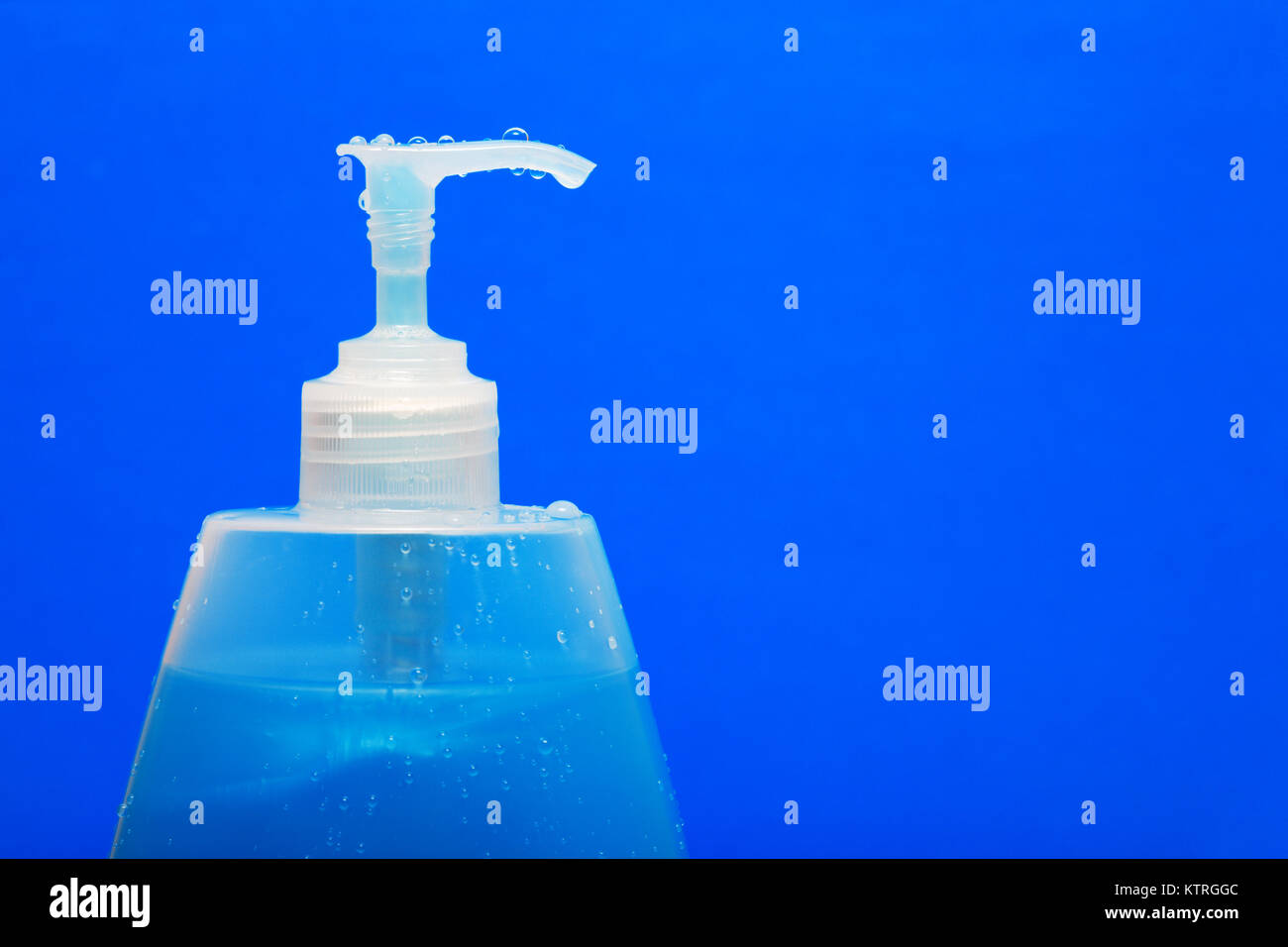 Closeup of plastic bottle of antibacterial liquid soap on a blue ...