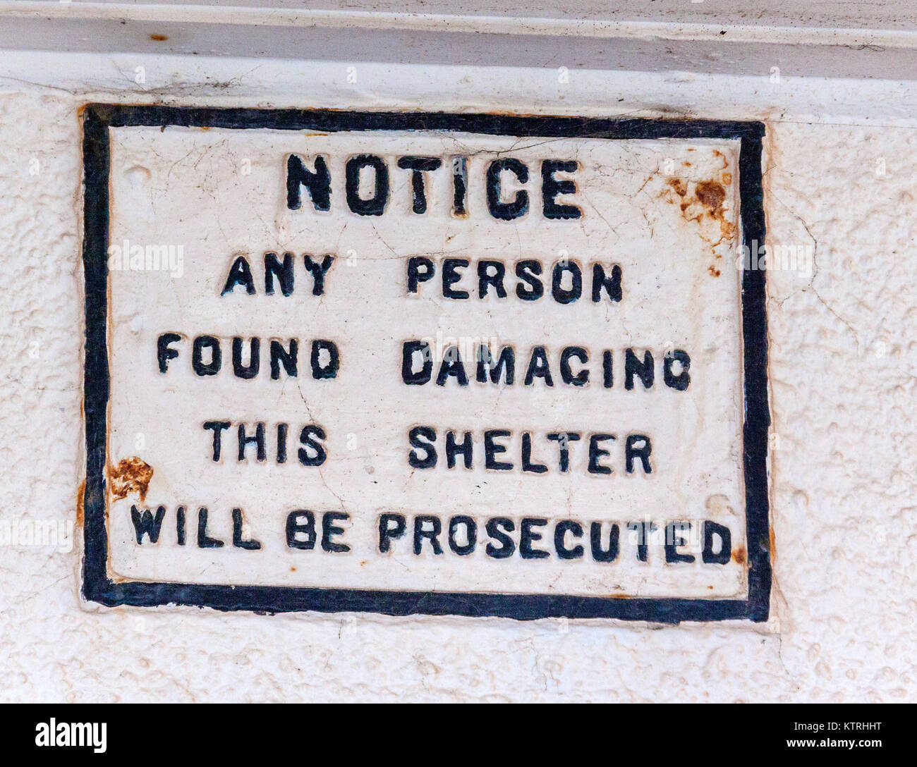 Old rusty warning sign - Notice any person found damaging this shelter ...