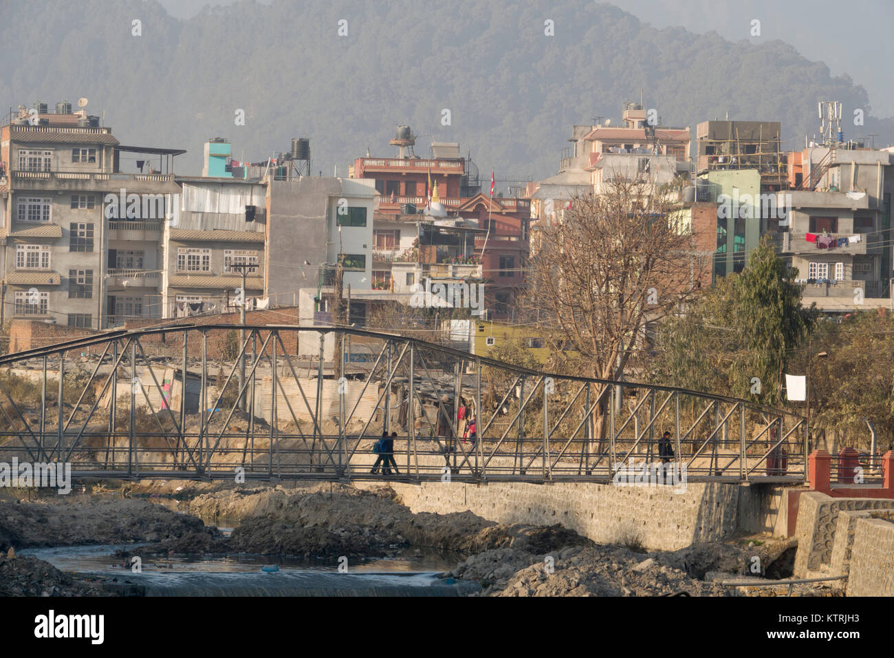 People walk across suspension bridge over the Bishnumati river in ...