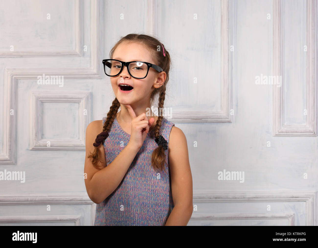 Happy thinking kid girl in fashion glasses with excited emotional face ...
