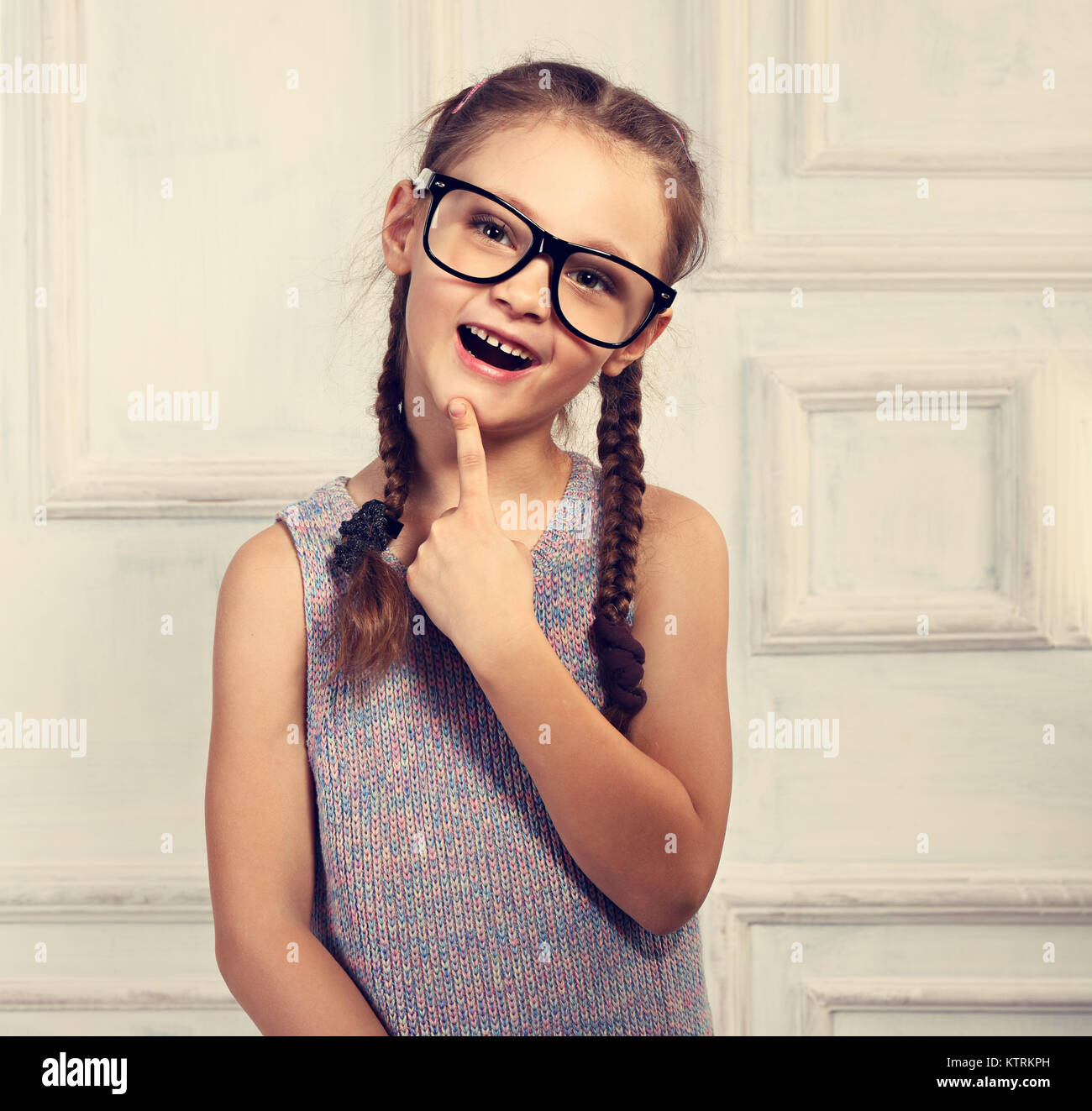 Happy thinking kid girl in fashion glasses with excited emotional face ...